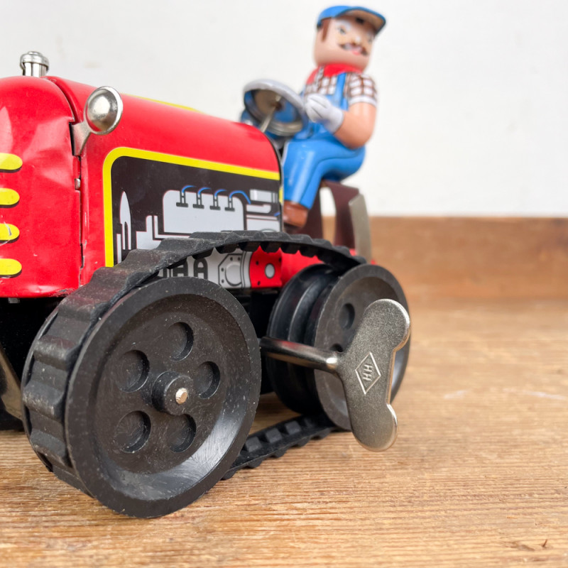 Red mechanical tractor and driver